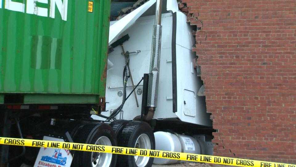 Tractor-trailer crashes into shopping center building