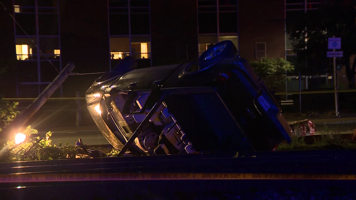 Driver injured when truck flips over, lands on train tracks
