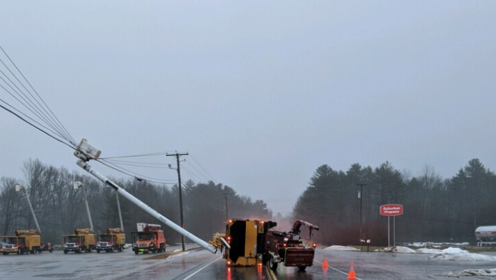 Boom truck flips after getting pole caught in power lines.