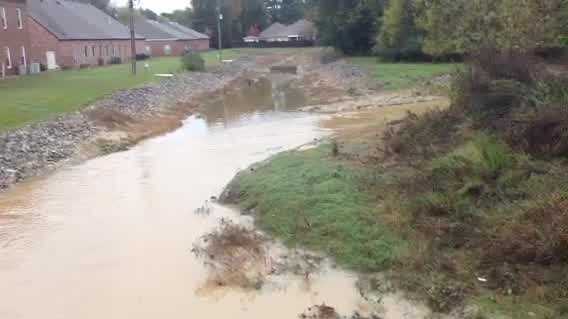 Water rushes through swollen drainage ditch