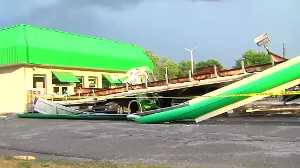 Gas station canopy collapses onto vehicles after storm winds move through