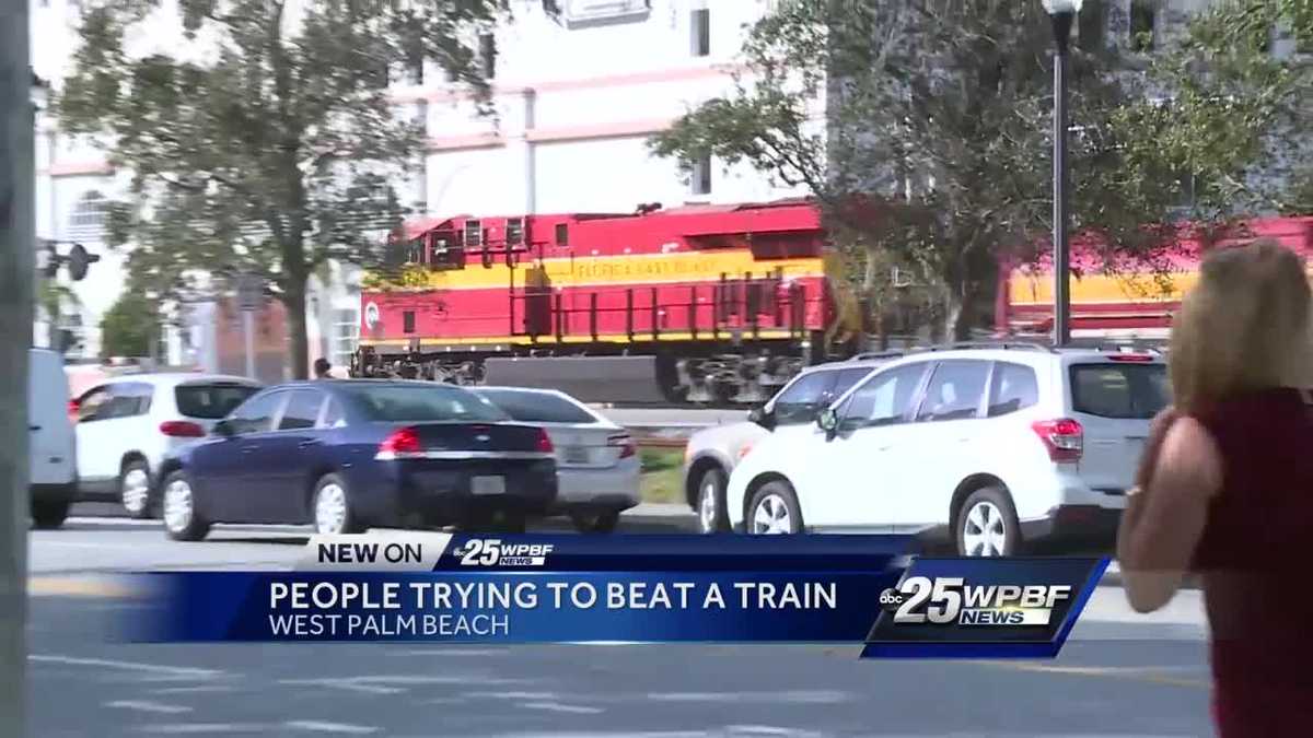 Video shows people trying to beat a train