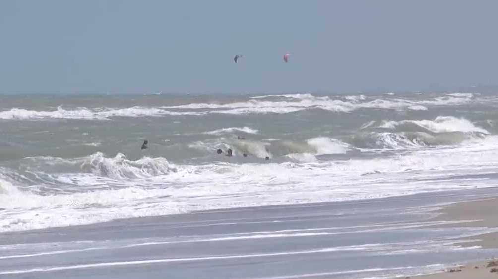 Bystanders rush into rough surf to save man pulled under by wave in ...