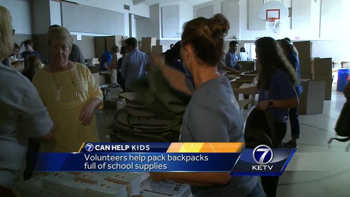 Volunteers help pack backpacks full of school supplies