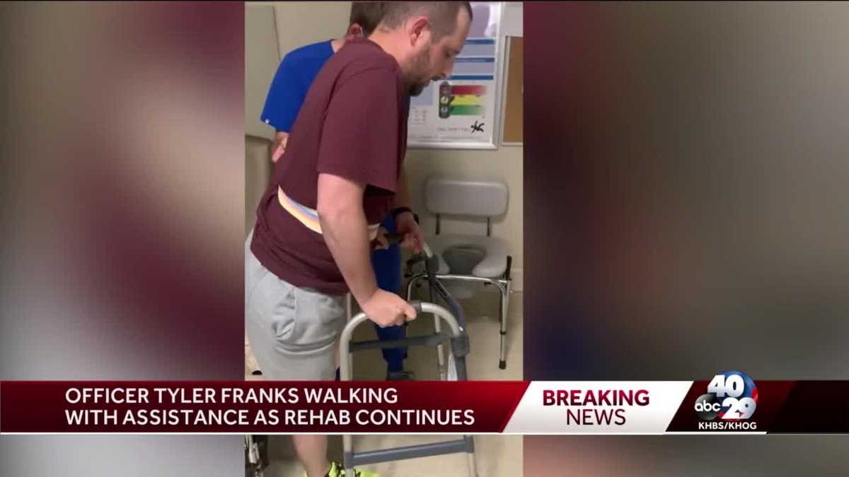 Officer Tyler Franks walking with assistance as rehab continues