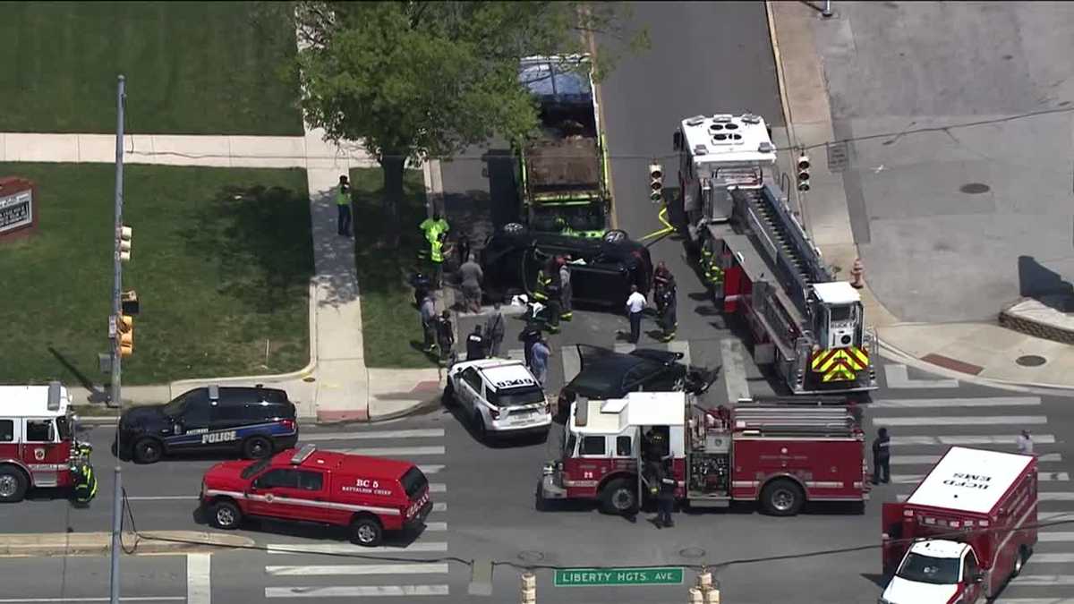 SUV turns onto its side in collision with trash truck