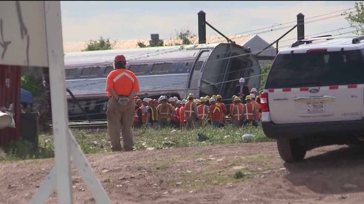 Residents watch in dismay as officials investigate train crash