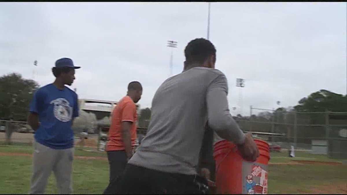 Players work on flooded baseball field