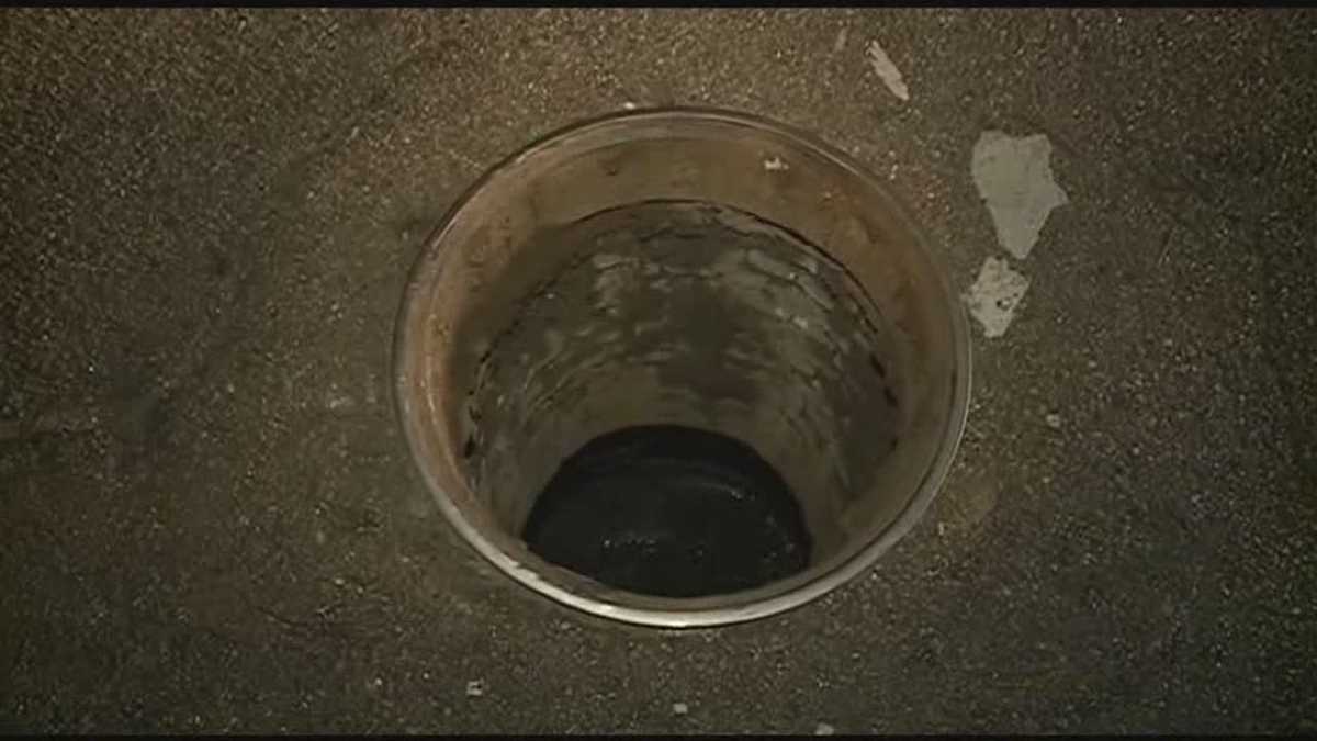 Car gets stuck in manhole