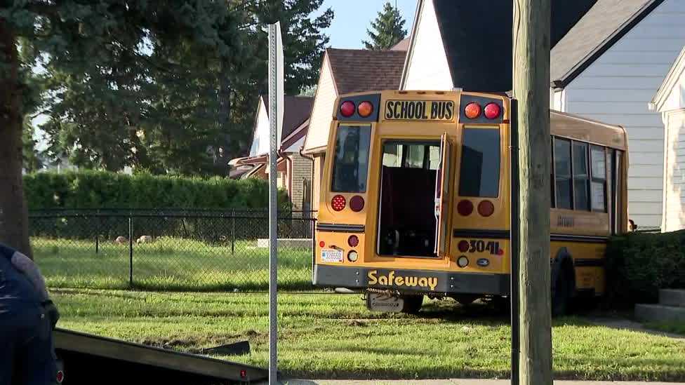 SUV hits school bus, sending it into family's front yard